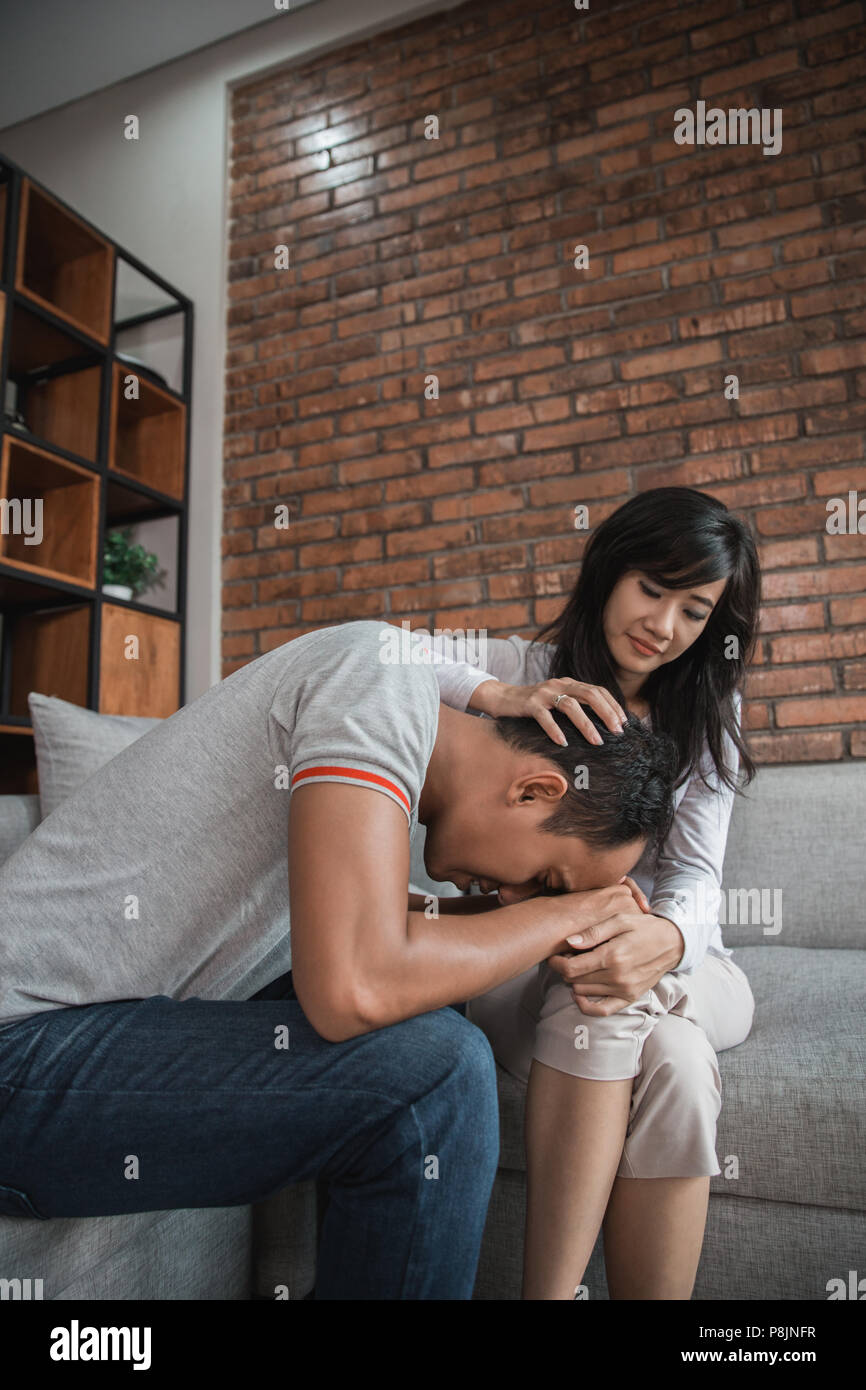 woman comforting her sad mourning man embracing him at home Stock Photo ...