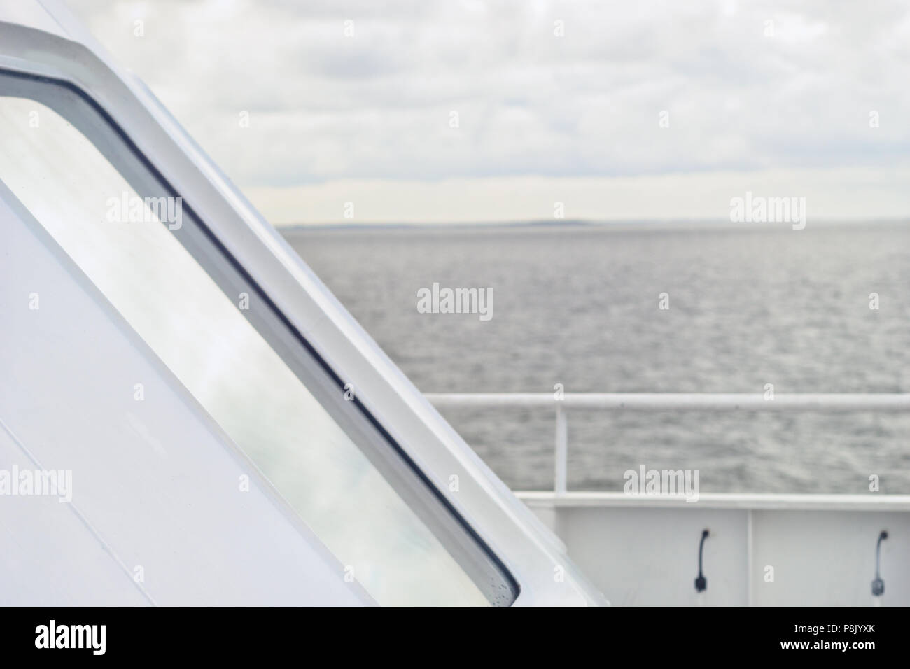 Window of a porthole on a ship on a cloud background and a railing on a ...