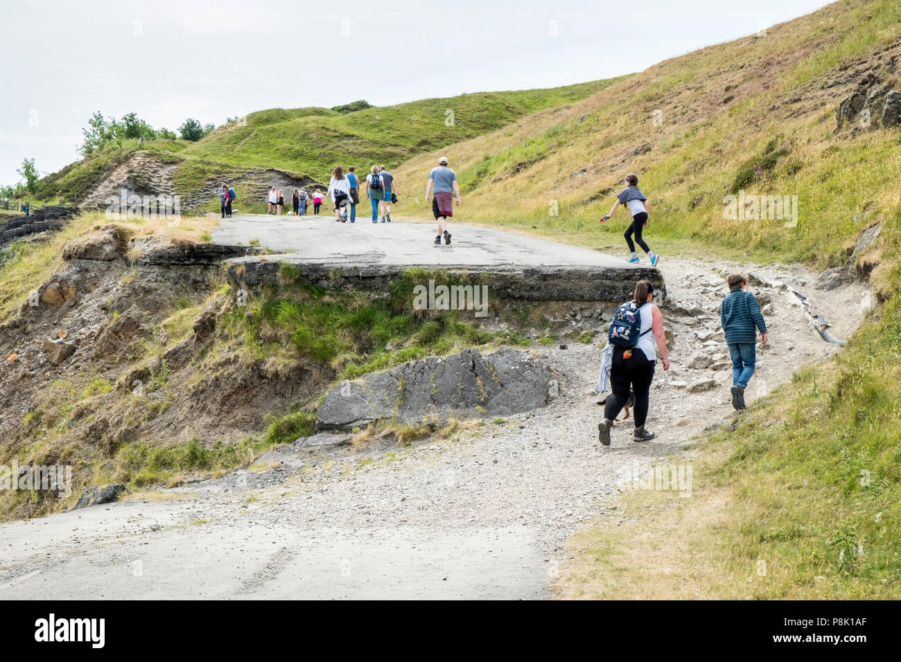 People walking on the abandoned and ruined road (A625) below Mam Tor ...