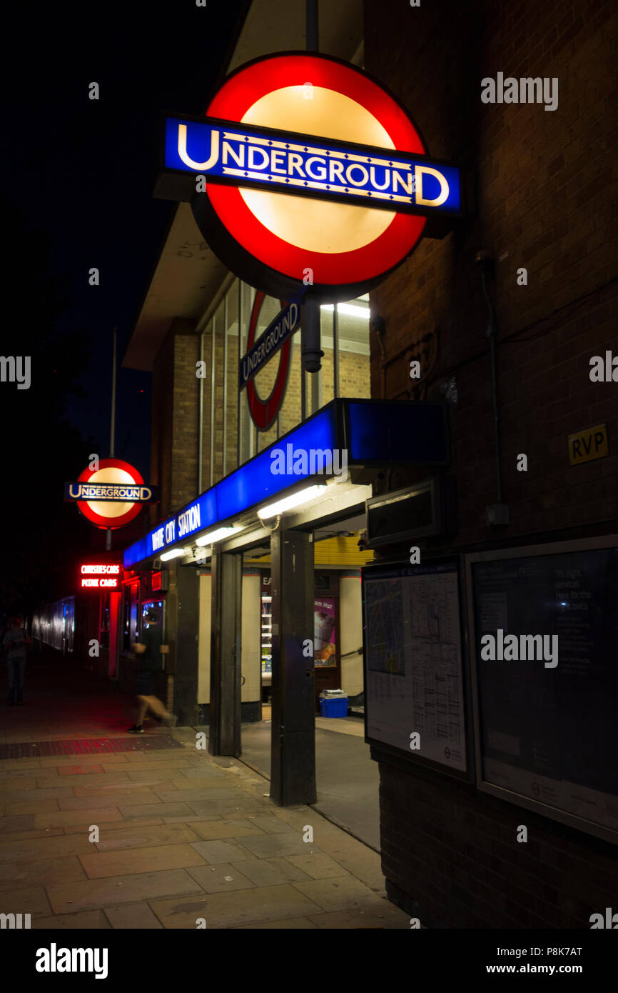 The entrance to White City underground station at night Stock Photo - Alamy