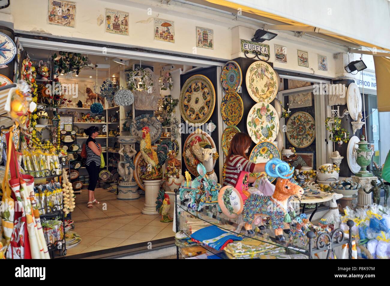 Shop on the street full of colorful objects, people shopping, front ...
