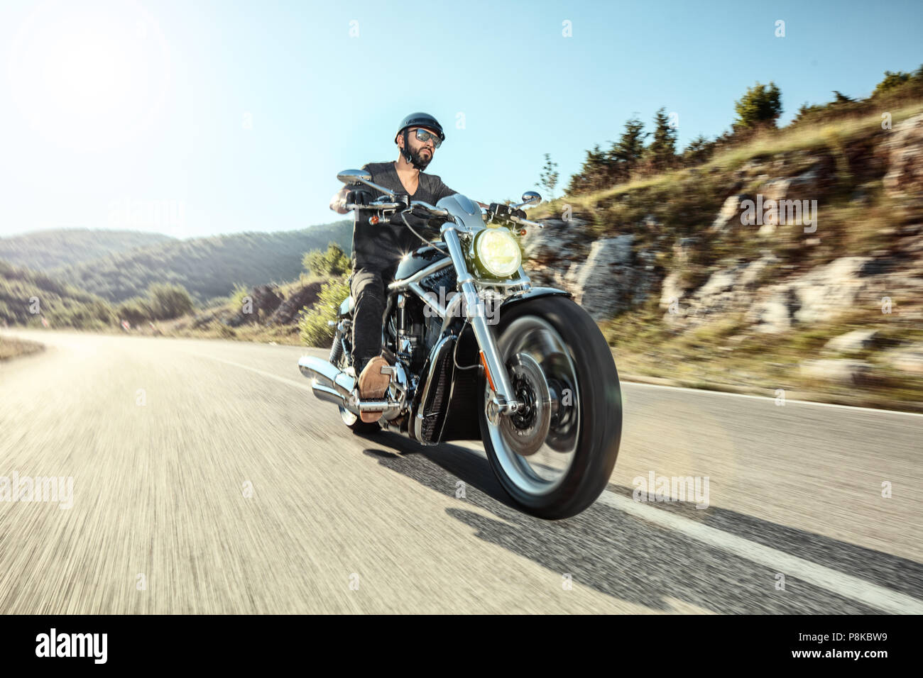 Young man riding a motorbike on the open road Stock Photo - Alamy