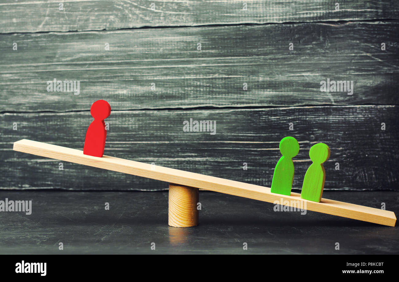 Figures of people are on the scales. Two people outweigh the third ...