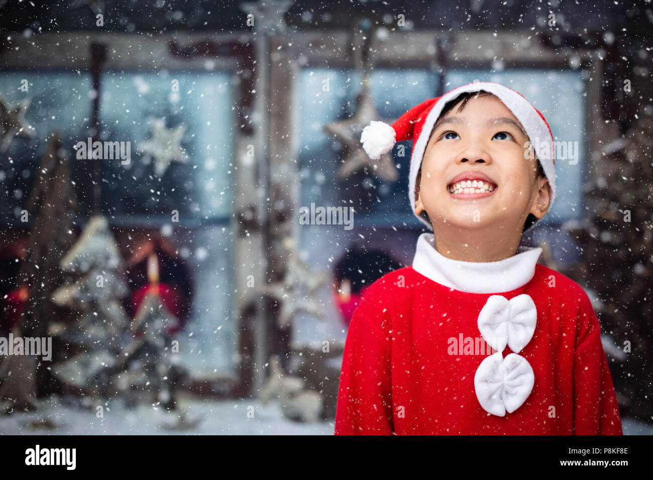 Asian Chinese little girl watching snowflakes outdoor during christmas ...