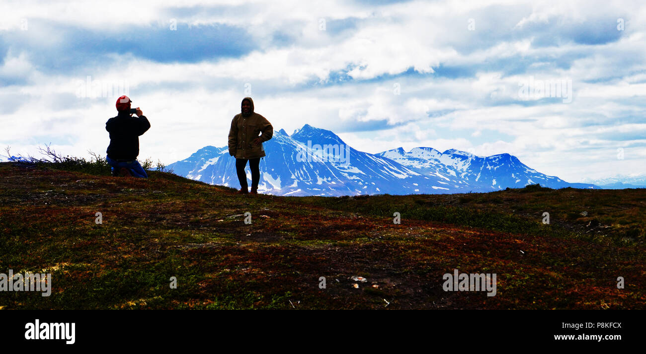 Tromso, Norway, Hiker on the mountain ledge Storsteinen enjoy the views ...