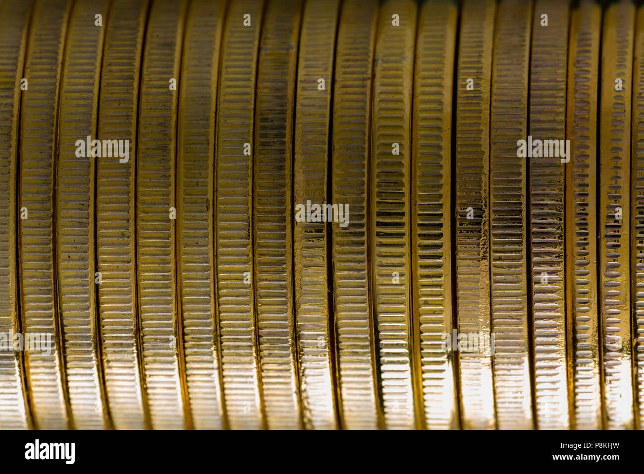 Close up on a horizontal stack of gold coins showing the detail of the ...