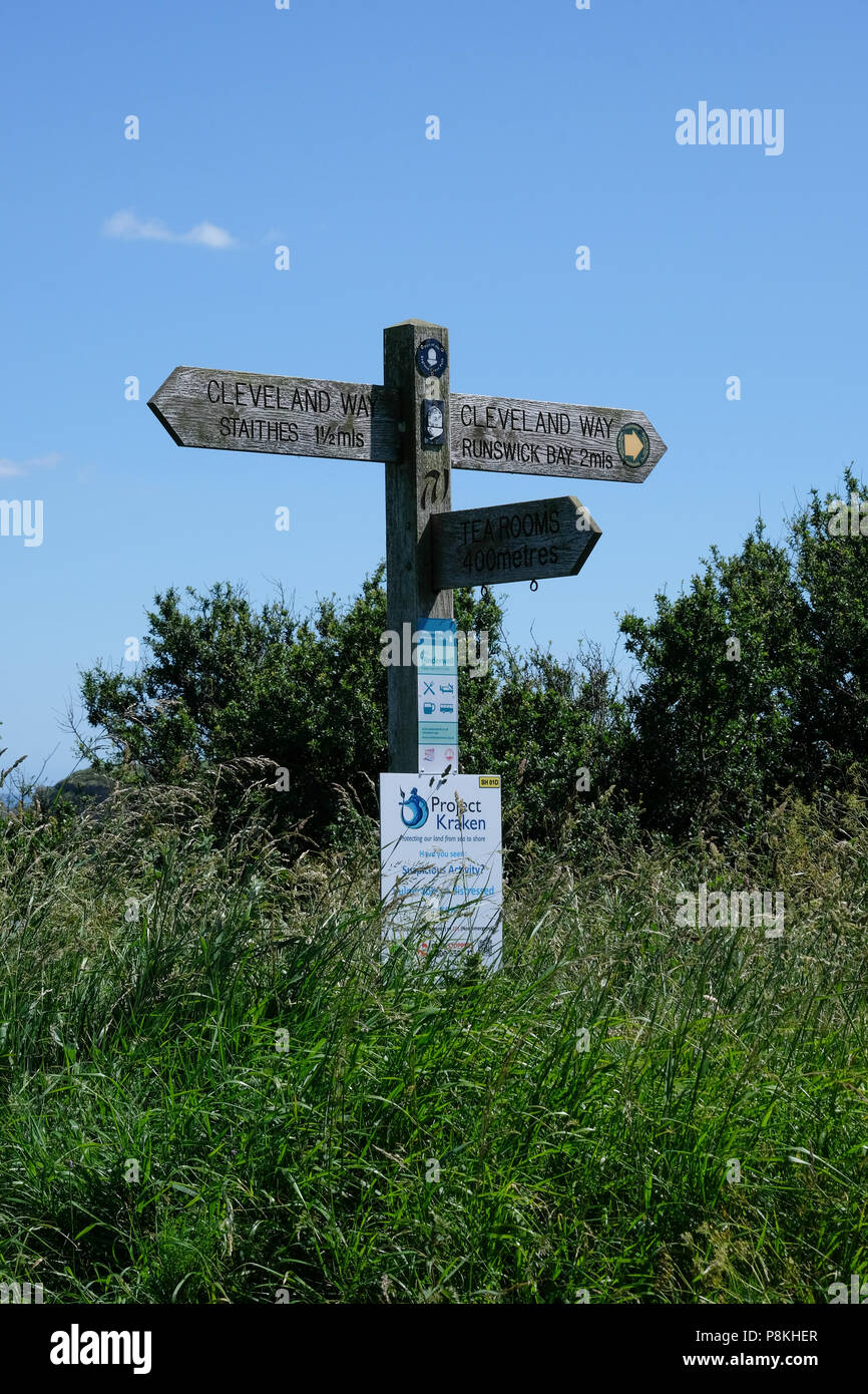 Sign post on the Cleveland Way above Port Mulgrave against blue sky and ...