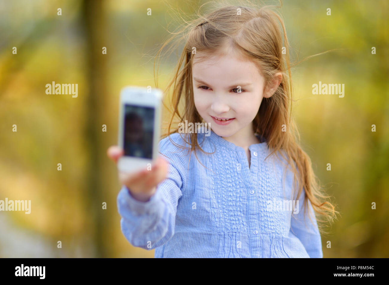 Adorable little girl taking a photo of herself on beautiful summer day Stock Photo - Alamy