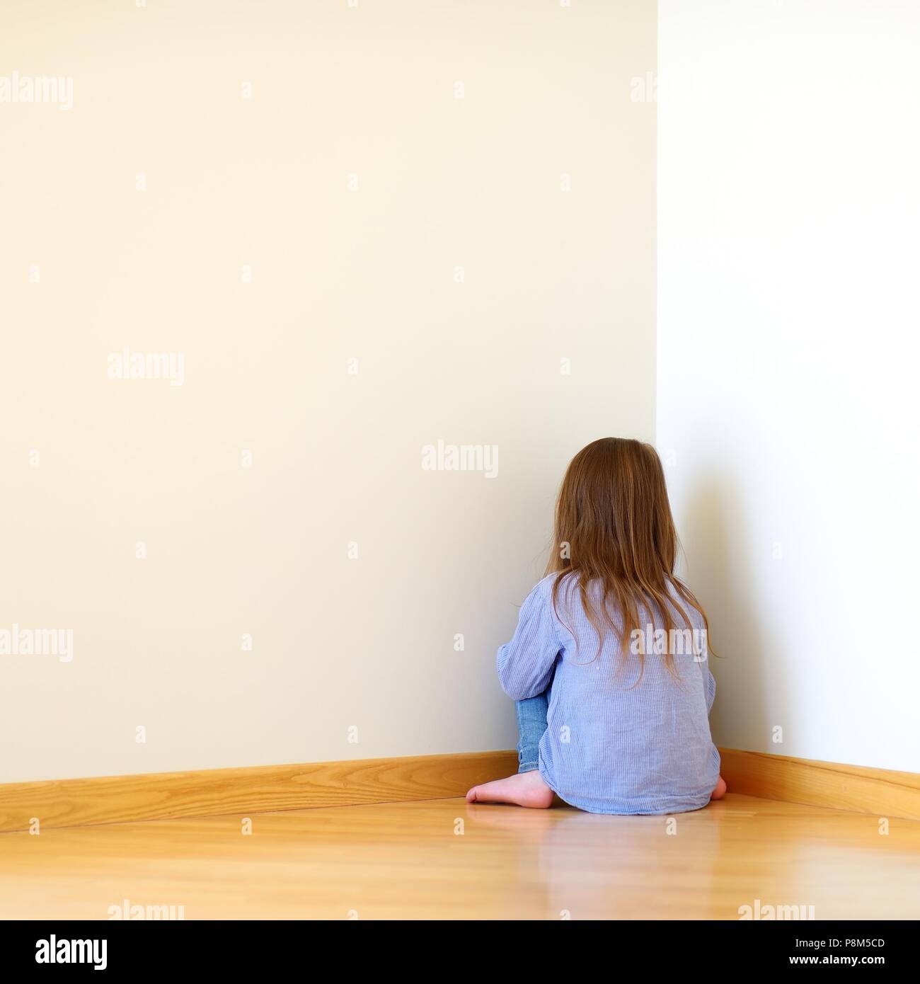 Very sad little girl sitting on a floor at home Stock Photo - Alamy