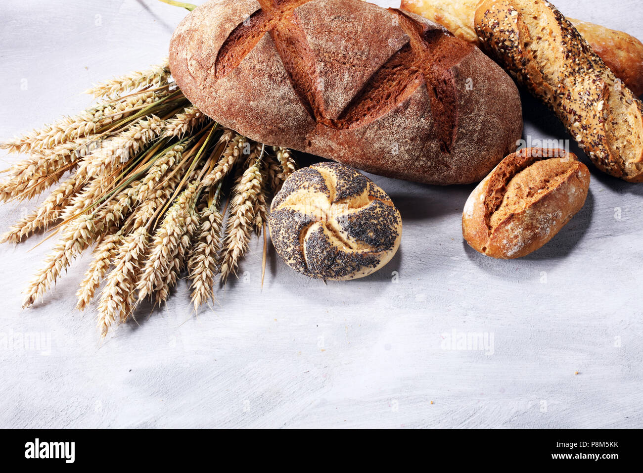 Different kinds of bread and bread rolls on board from above. Kitchen ...