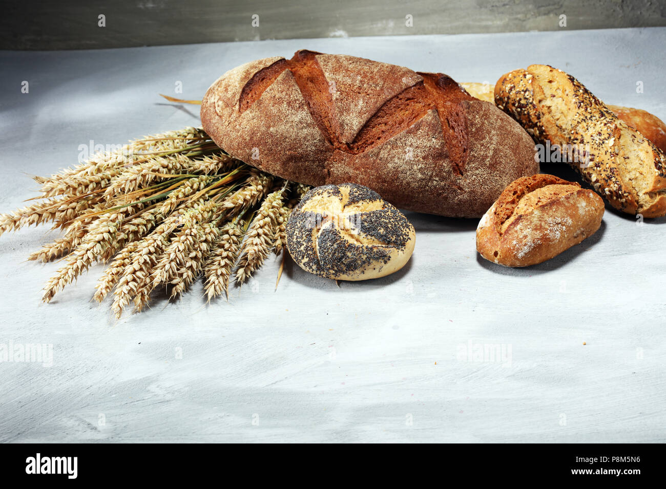 Different kinds of bread and bread rolls on board from above. Kitchen ...