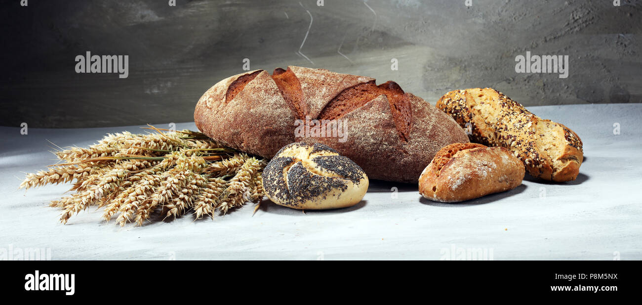 Different kinds of bread and bread rolls on board from above. Kitchen ...