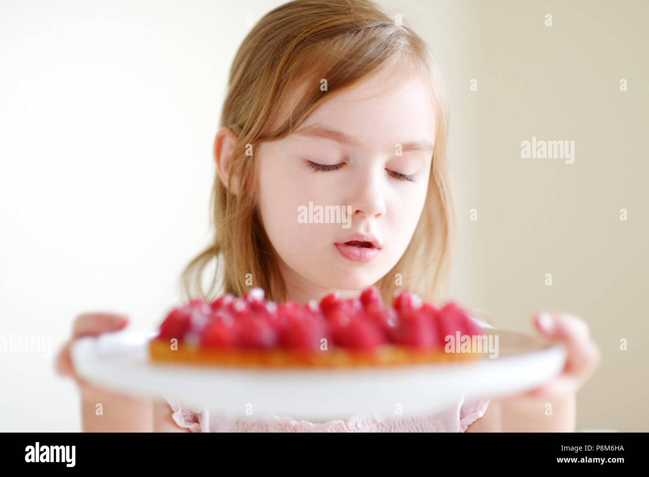 Adorable little girl and delicious raspberry cake Stock Photo - Alamy