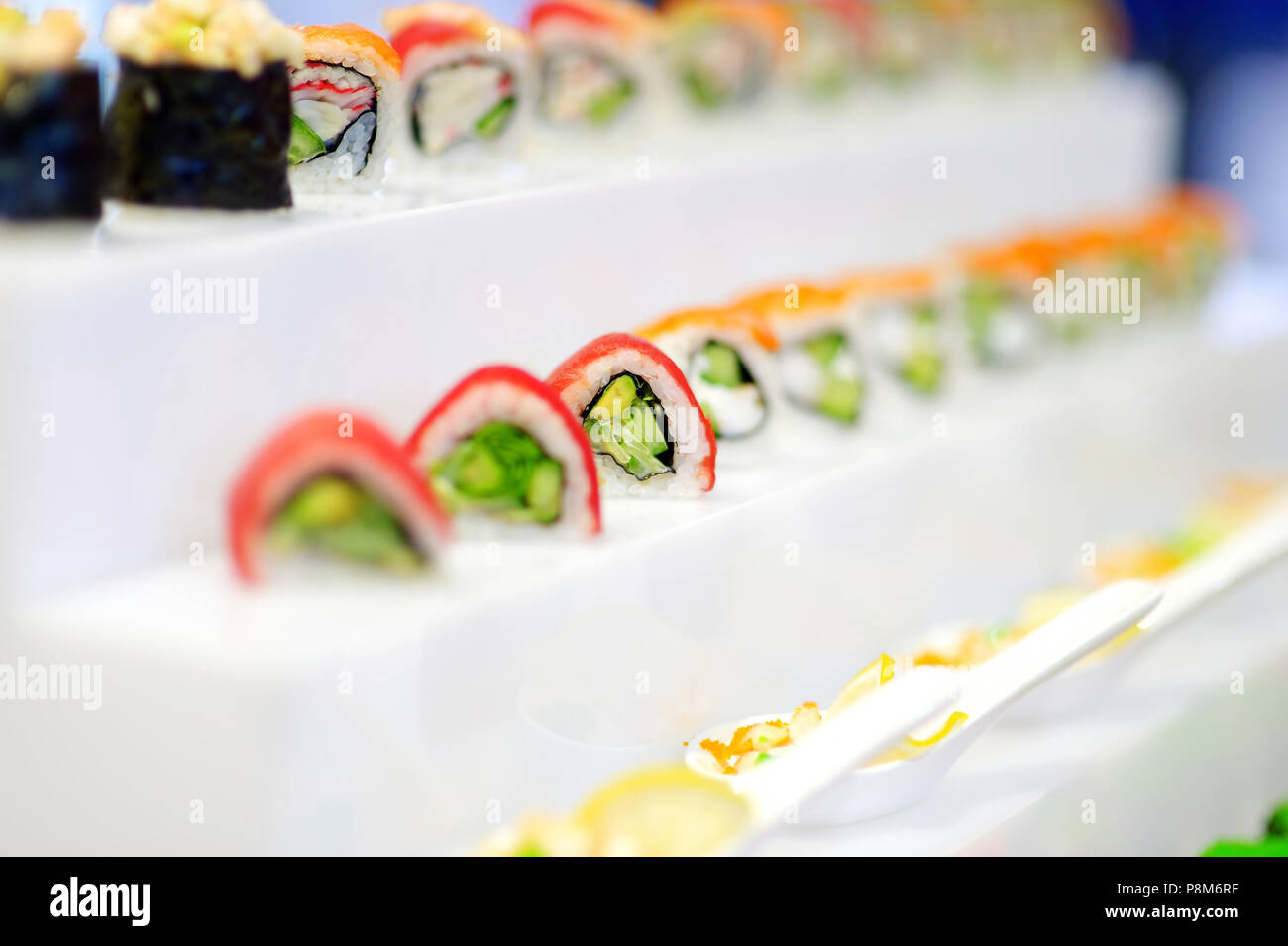 Delicious sushi with avocado topping on rolled seafood and rice ...