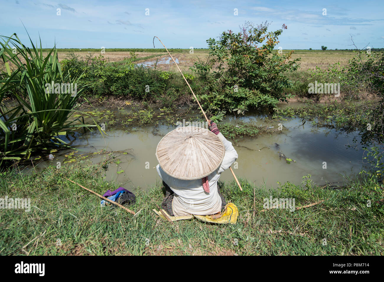 a women is fishing at a water Khmer Management System and canal in the ...