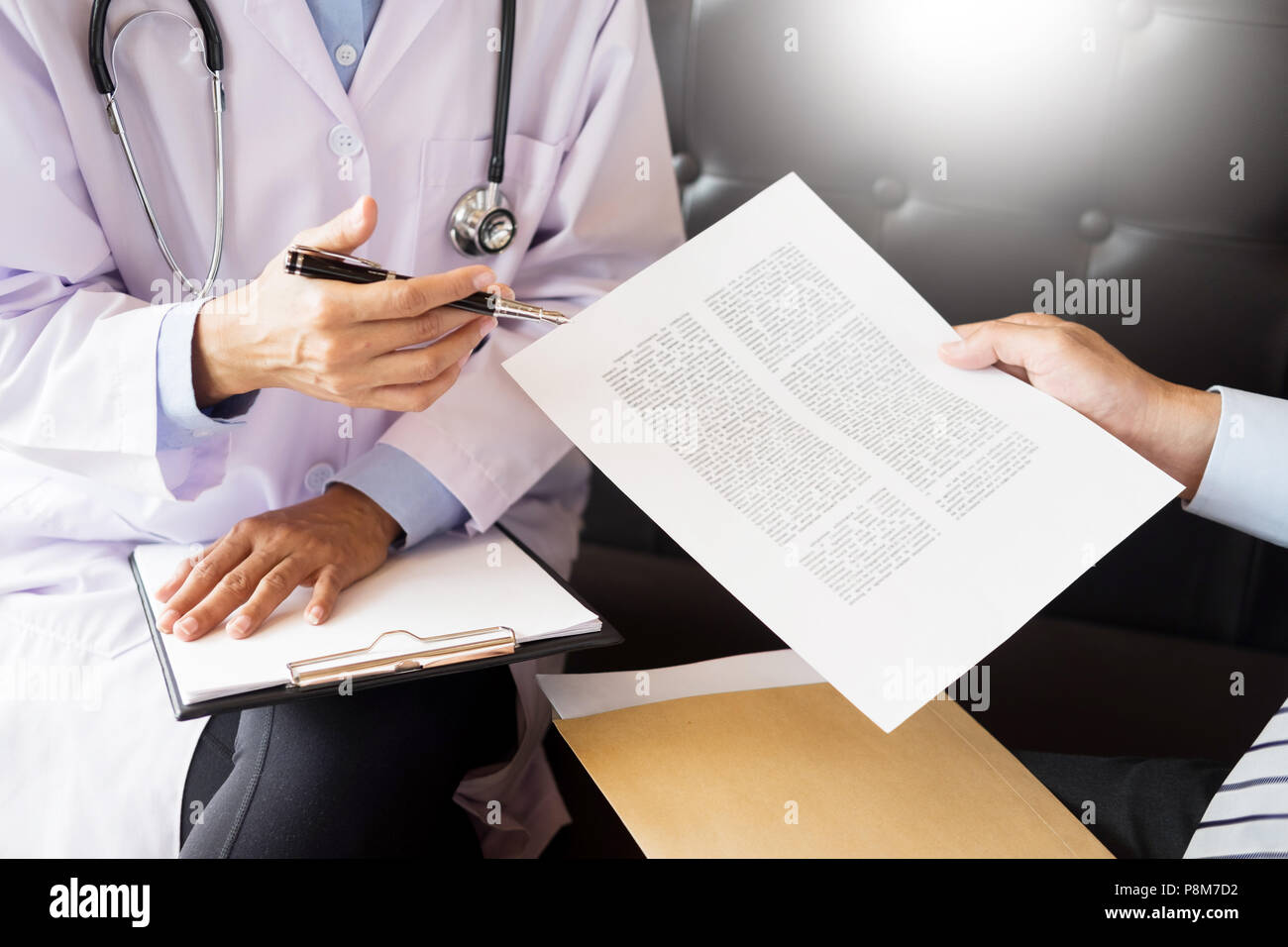 Doctor informing patient's of diagnosis medical record from paper in ...