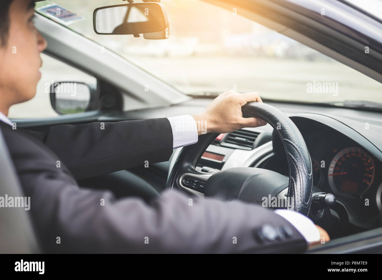 Portrait of a young handsome businessman driving a luxury sports car ...