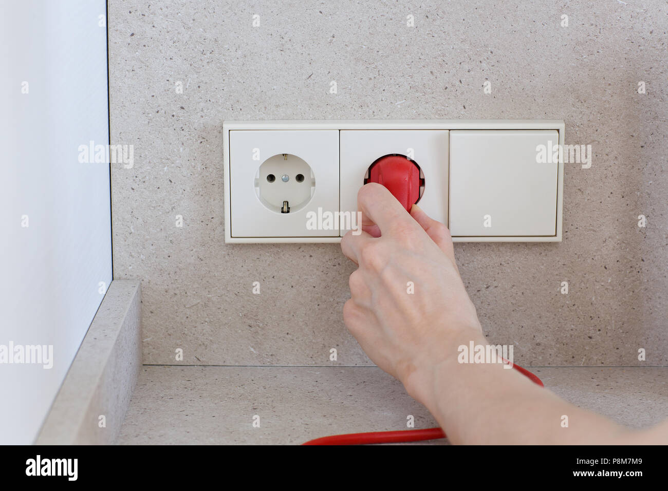 Woman plugged in an electric device in a triple power socket Stock ...