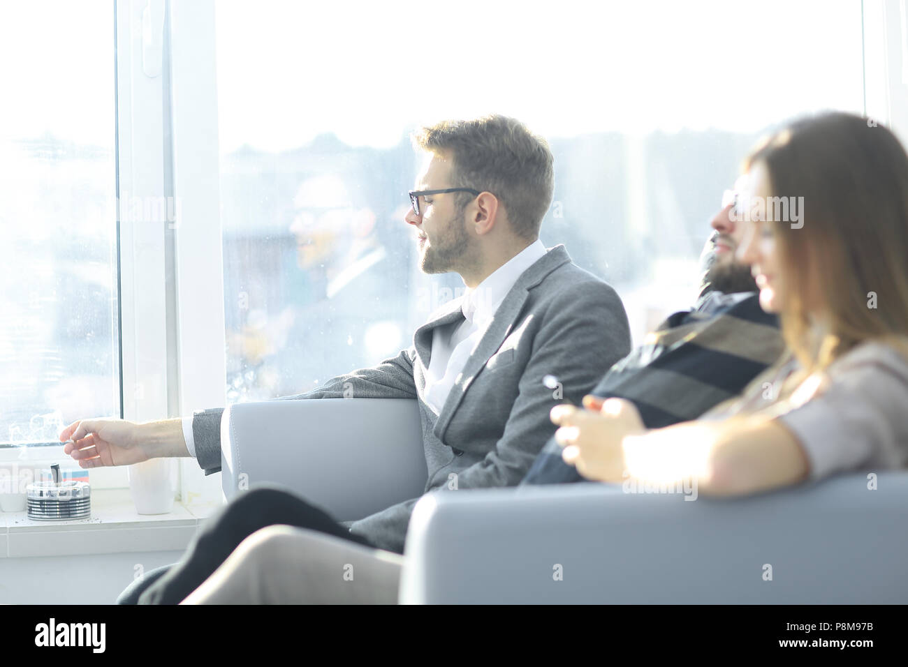 business team sitting on the couch during work break Stock Photo - Alamy