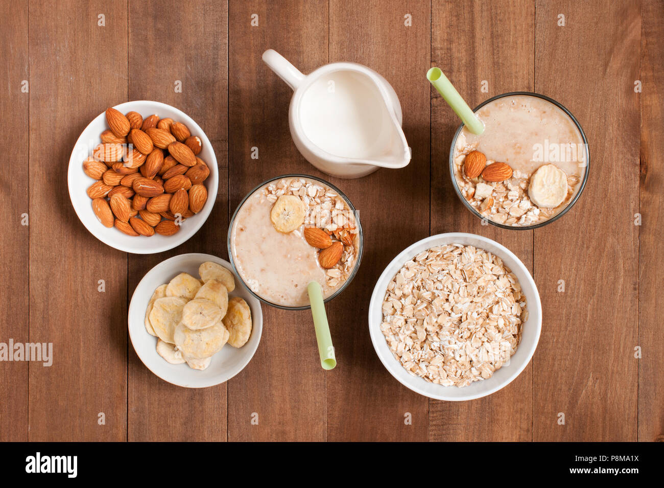 Ingredients and two portion of smoothies on the textured wooden table ...