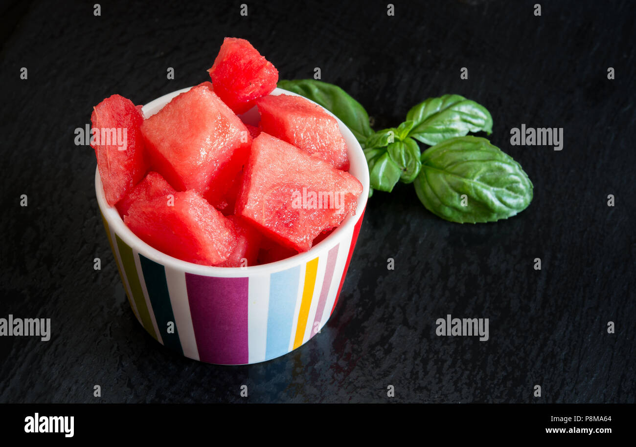 red and sweet watermelon diced in little cup on black background Stock ...