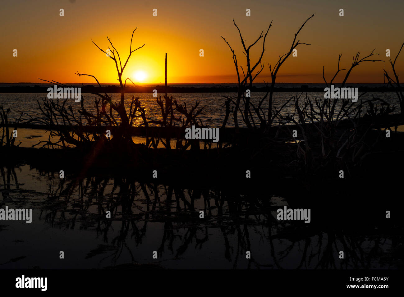 Sunset on the beach in an abandoned city with the sun in the back over ...