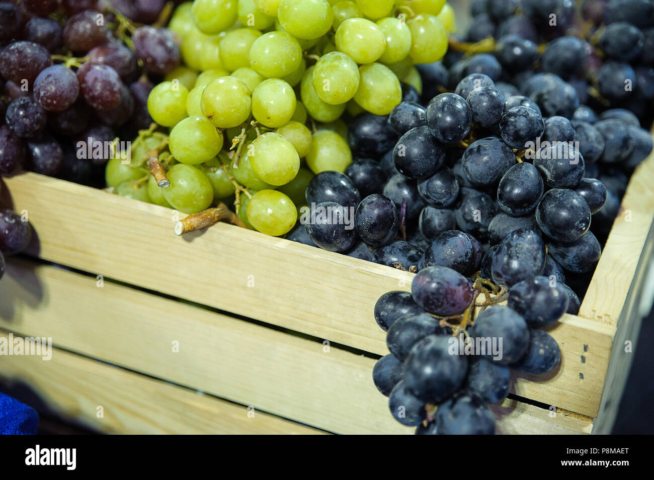 Freshly picked varieties of grapes in a wooden pallet at the Farmer's ...
