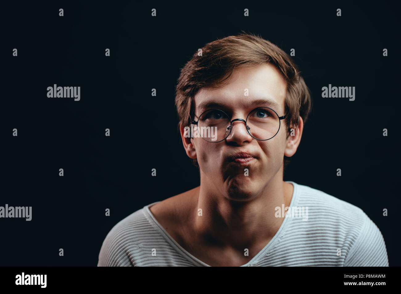 close up portrait of handsome pensive young man with curling mouth ...