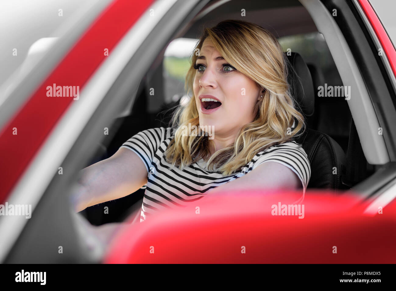 The woman driving the car in a panic Stock Photo - Alamy