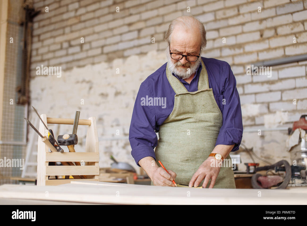 old wood worker spending time in the workshop. close up photography ...