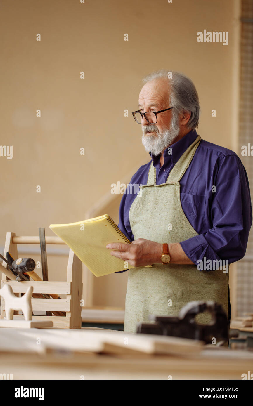 old shop teacher holding the register is doing a roll call at the ...