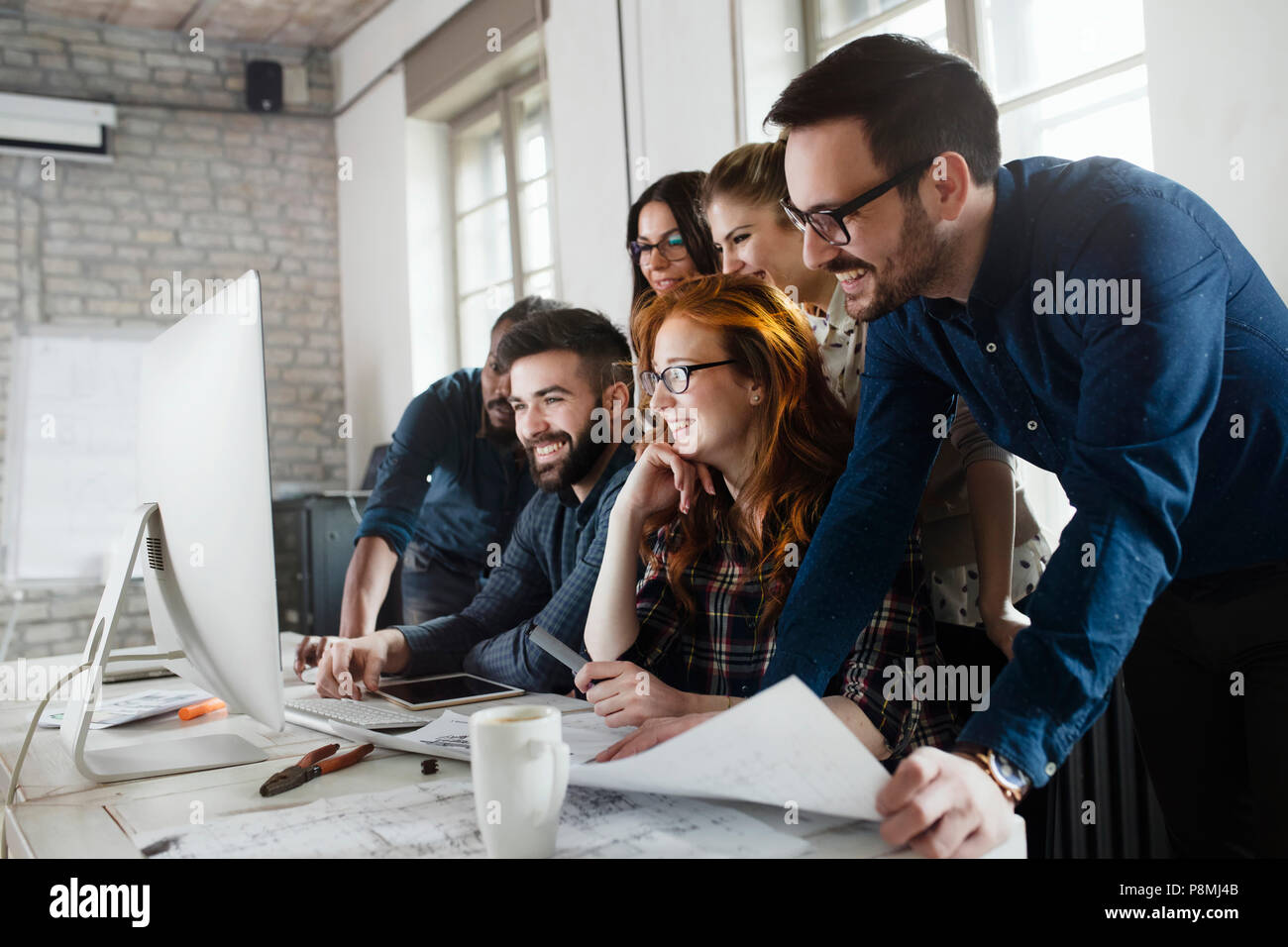 Group of young designers working as team Stock Photo - Alamy