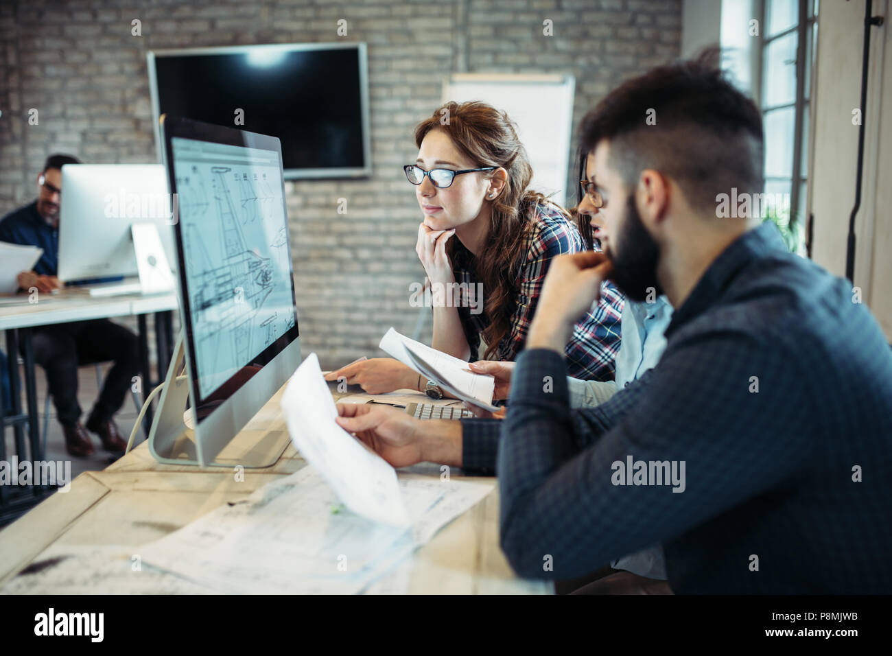 Young architects working on project in office Stock Photo - Alamy