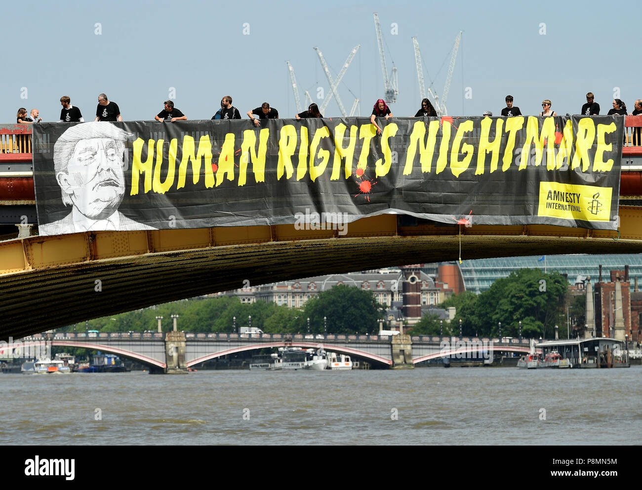 Amnesty International unveil a banner on the Vauxhall Bridge in London ...
