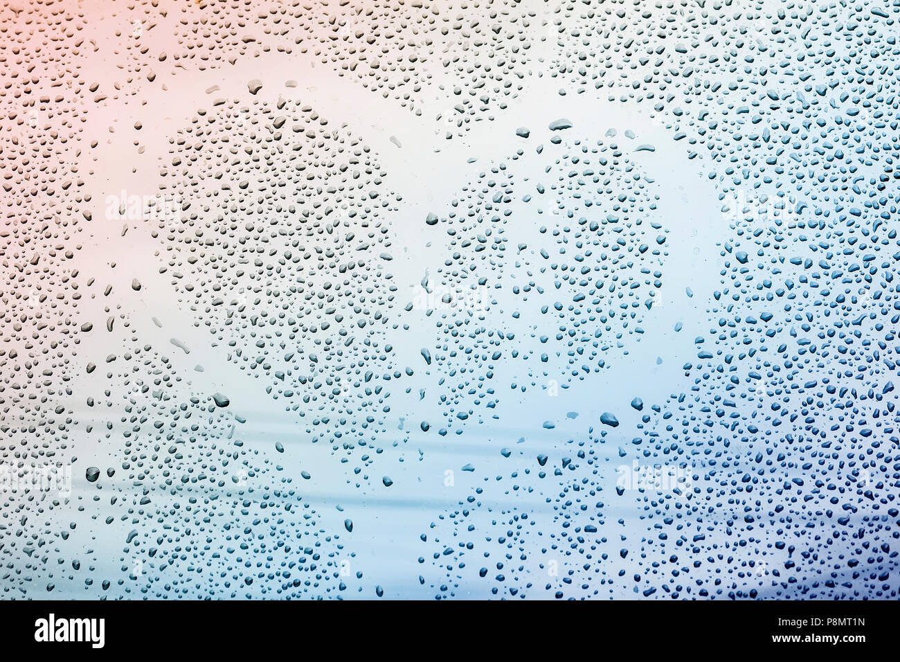 Water raindrops, romantic heart painted on the window glass. Rainbow ...