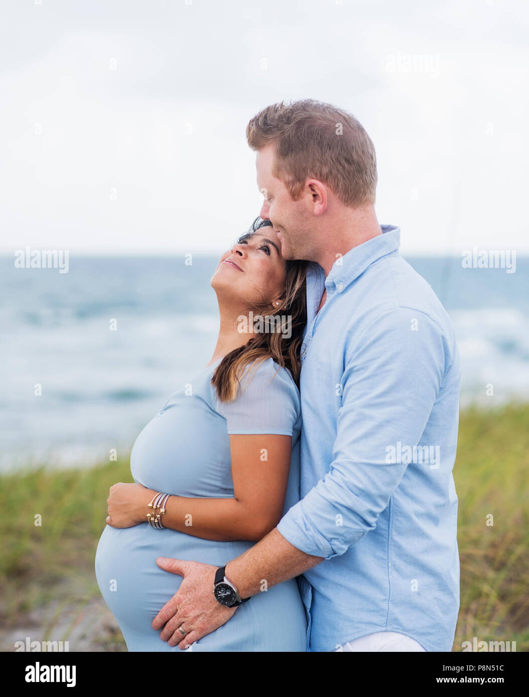 Pregnant couple embracing Stock Photo - Alamy