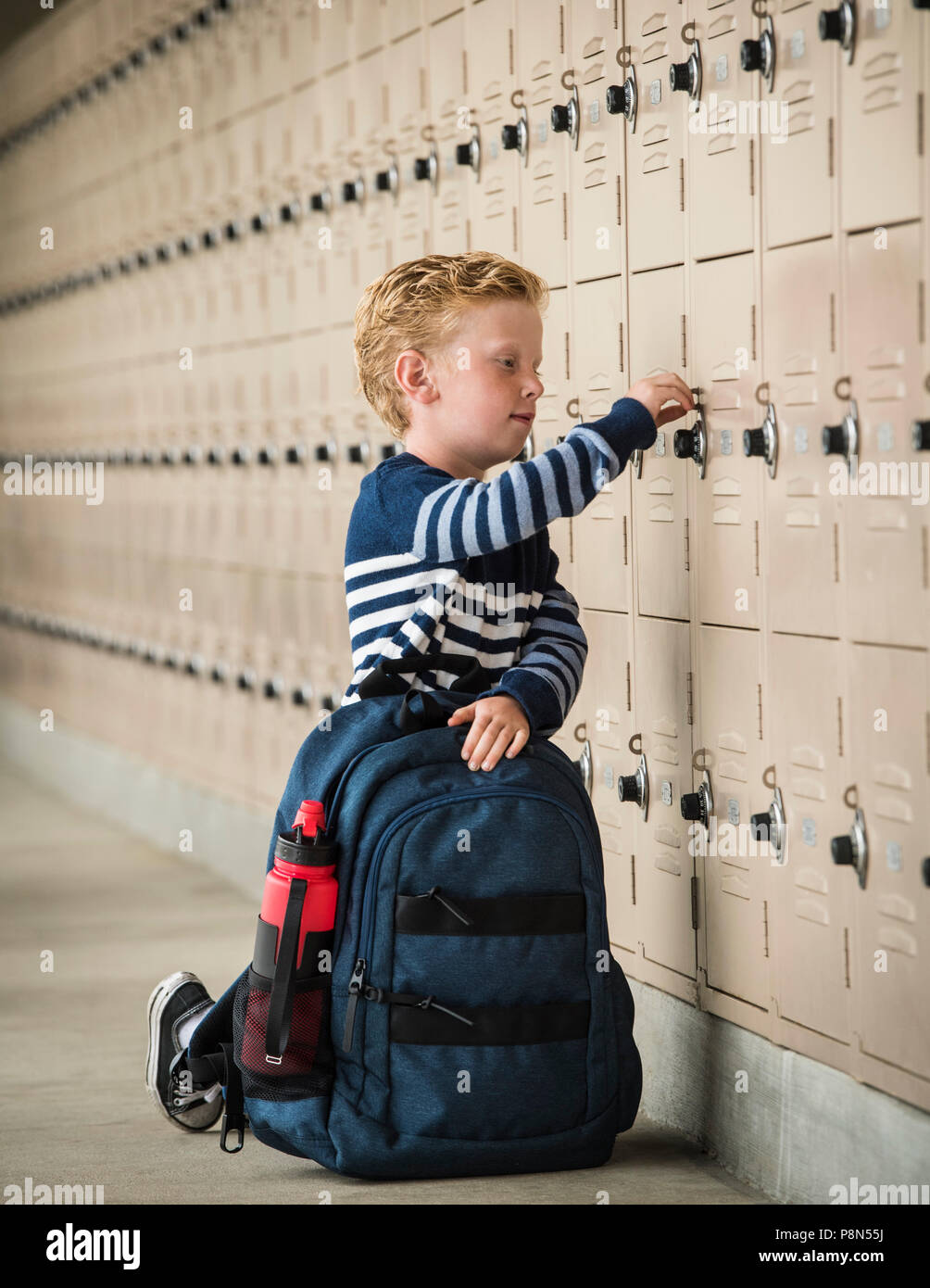 Boy with backpack by school lockers Stock Photo - Alamy