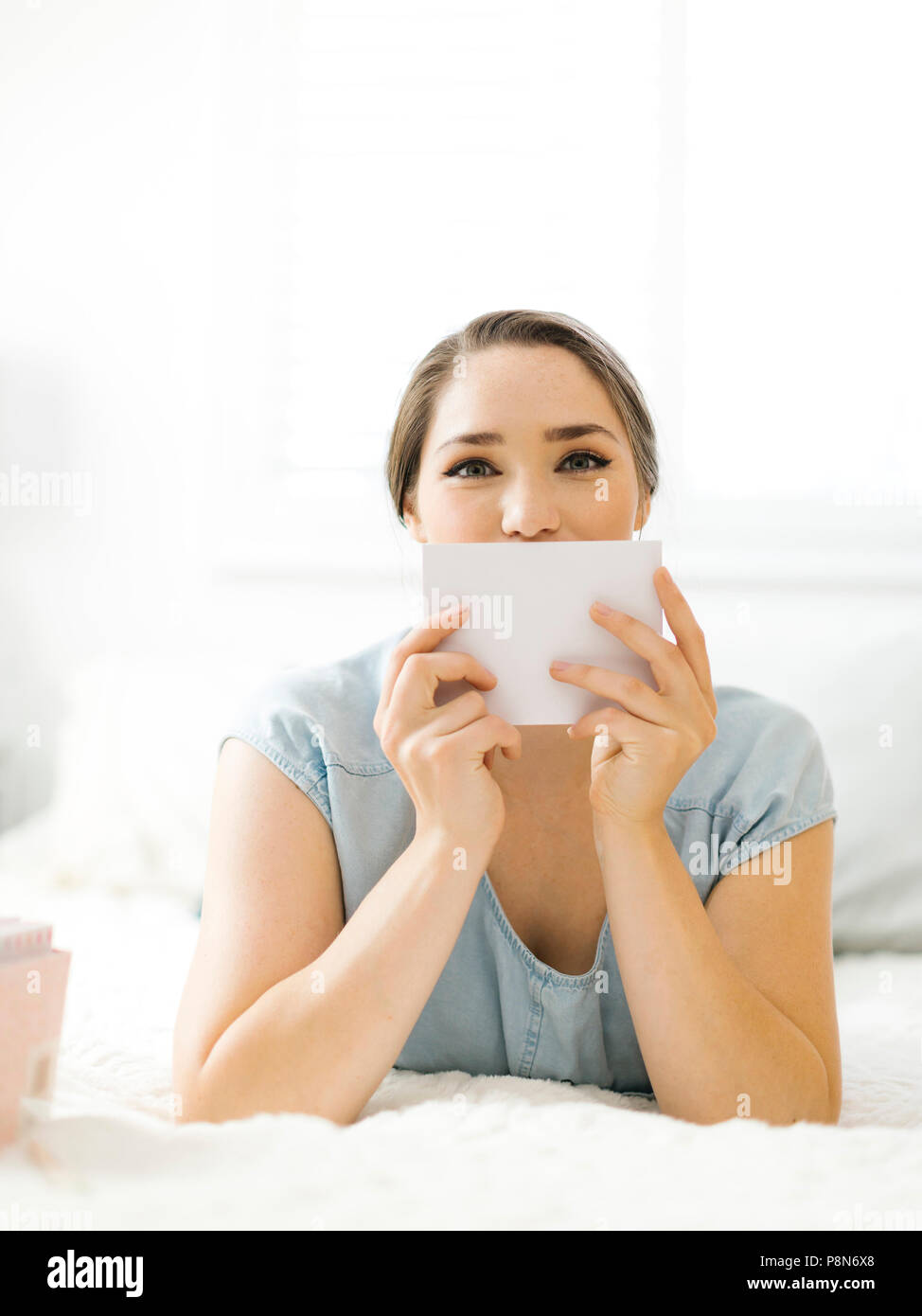 Woman holding envelope on bed Stock Photo - Alamy