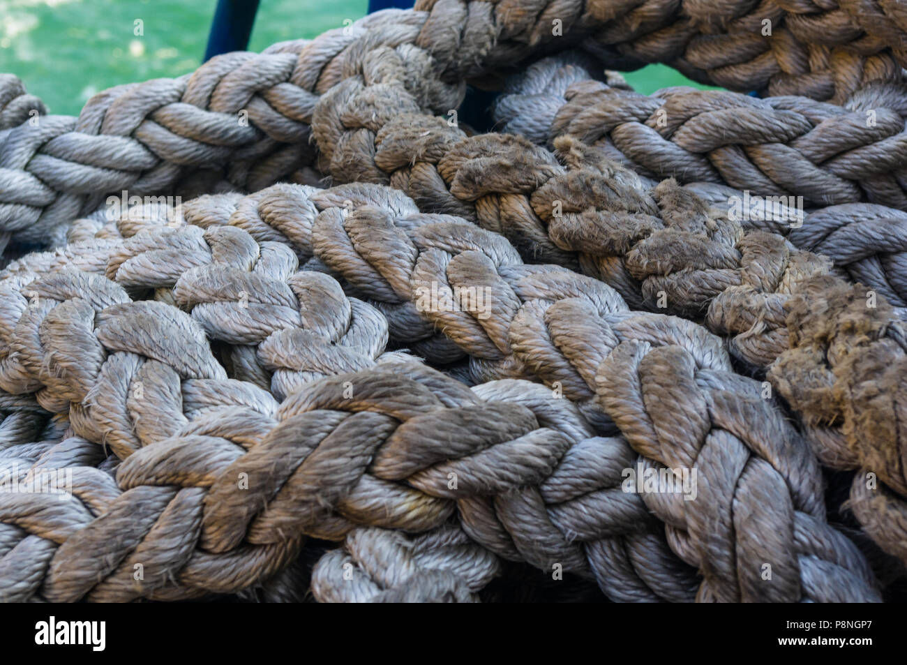 Old braided rope on the wooden deck of a sea boat, cleats, anchor ...