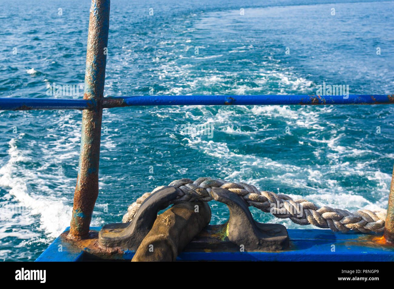 Old braided rope on the wooden deck of a sea boat, cleats, anchor ...
