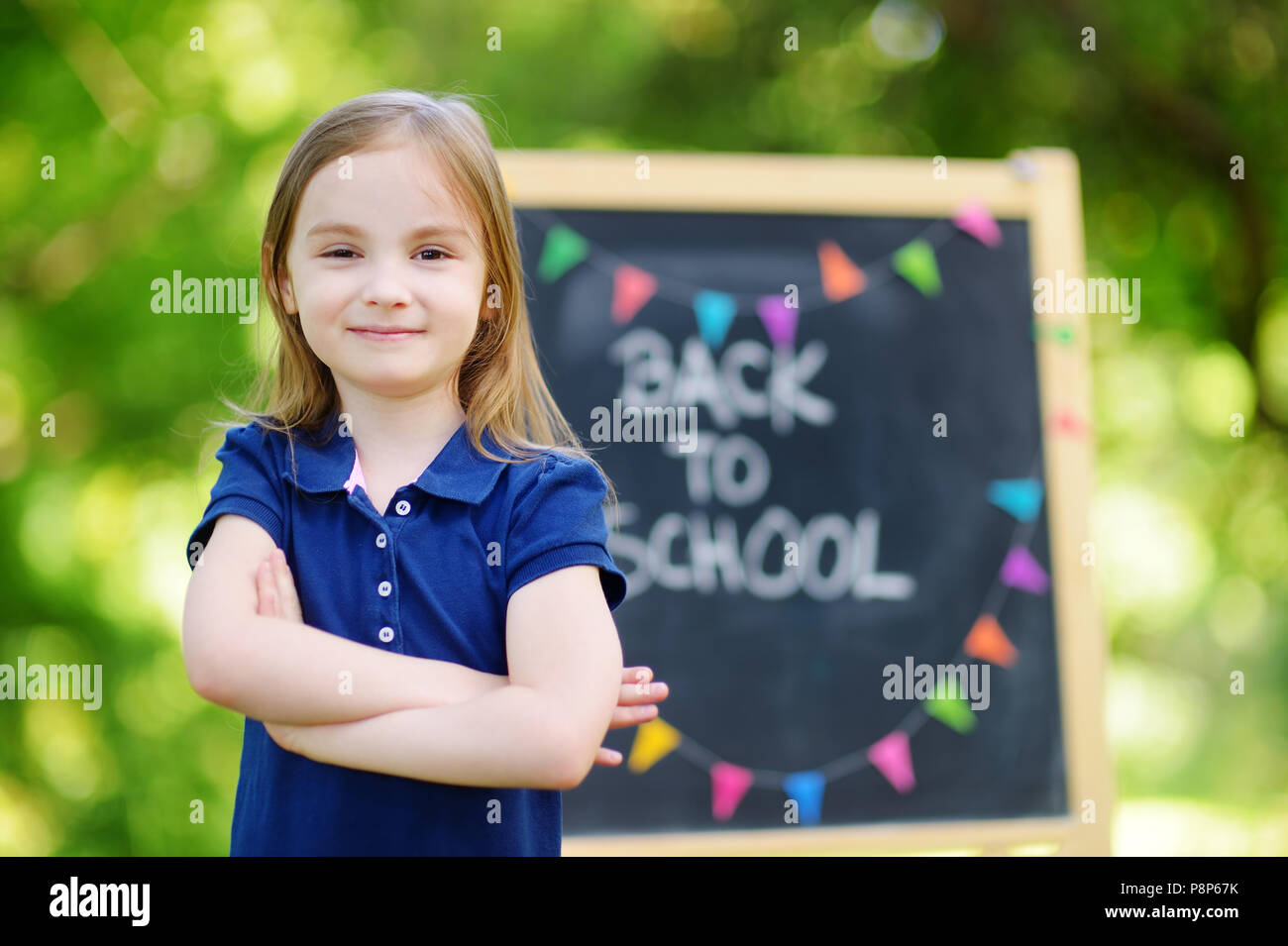 Adorable little schoolgirl feeling very excited about going back to ...