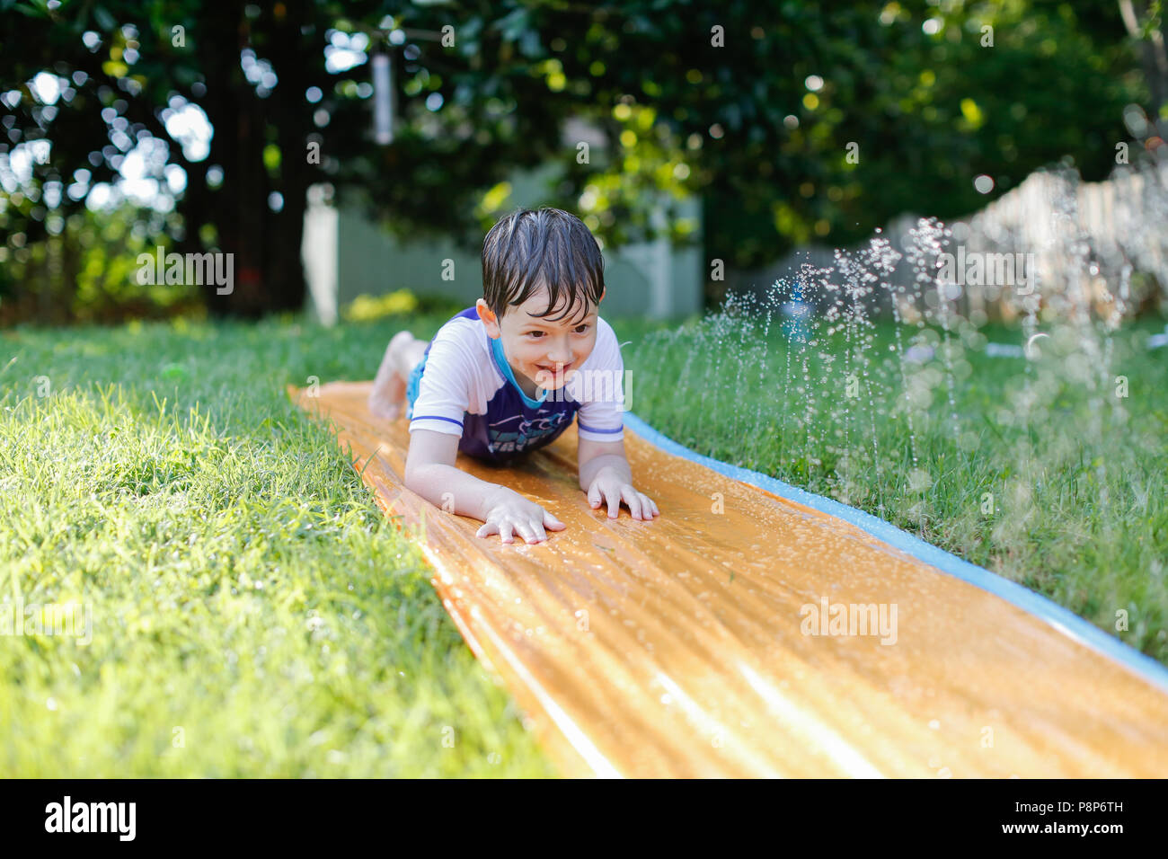 Boy sliding on Slip n slide in yard in the summer. Photo credit ...