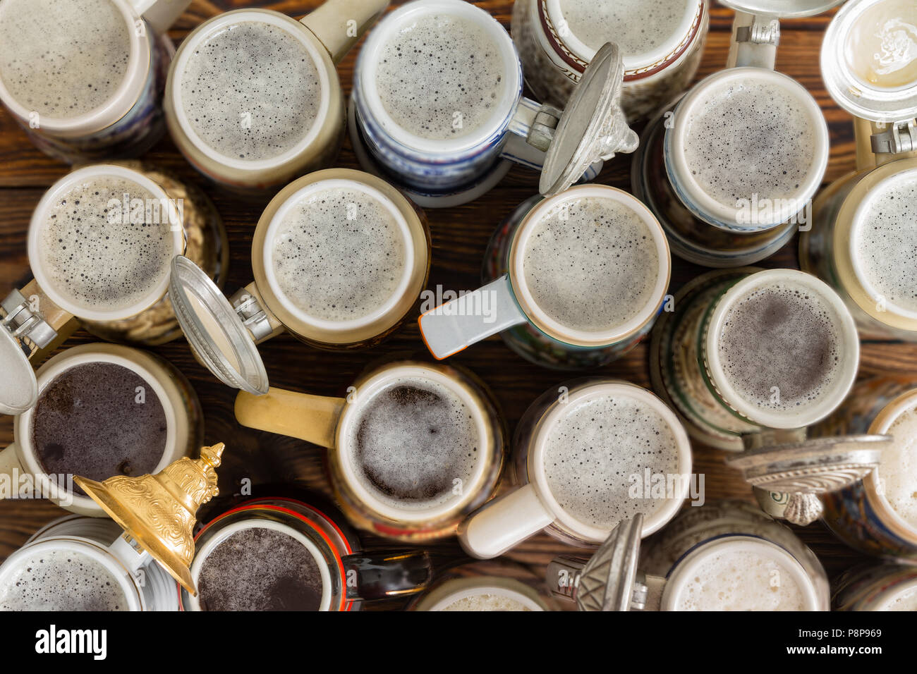 An assortment of full, frothy german beer mugs on a bar bench top Stock ...
