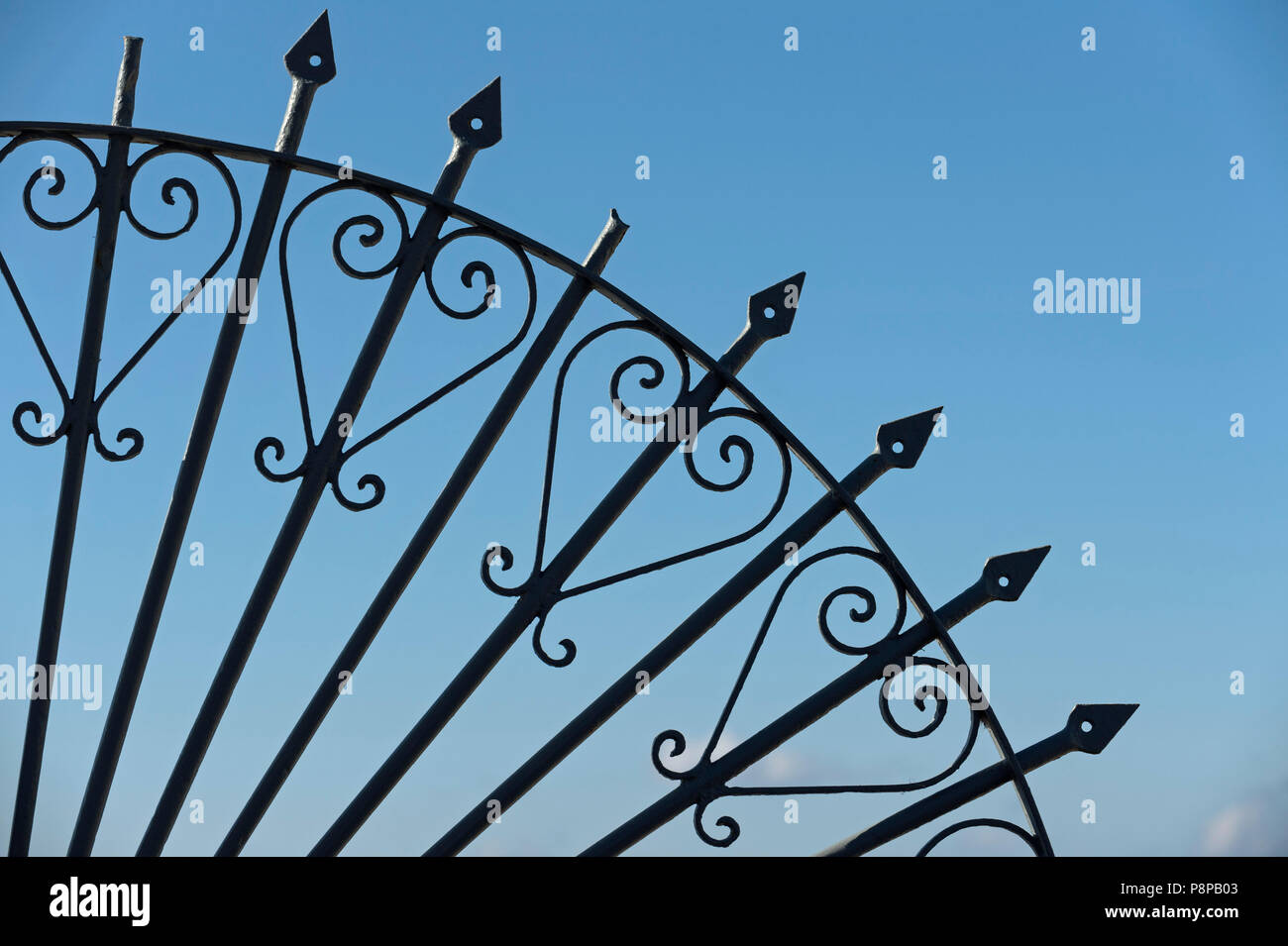 Decorative black wrought iron structure against blue sky, Santorini ...