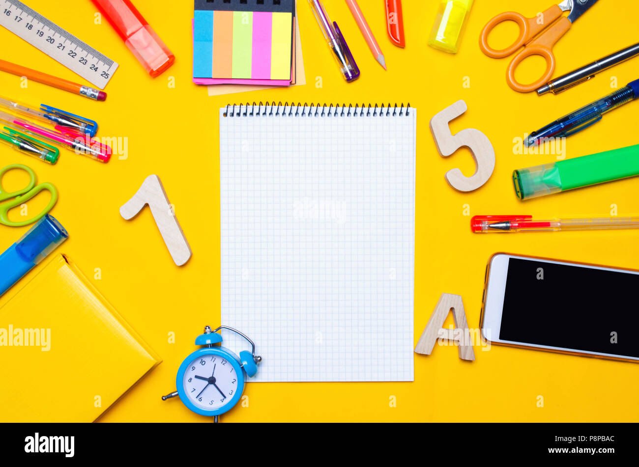 school accessories on a desk on a yellow background. concept of ...