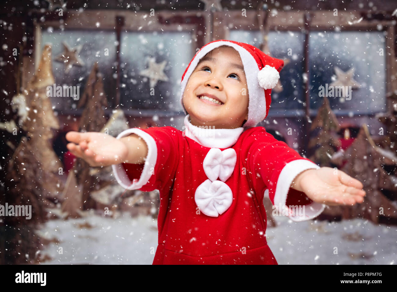 Asian Chinese little girl playing with snowflakes outdoor during ...