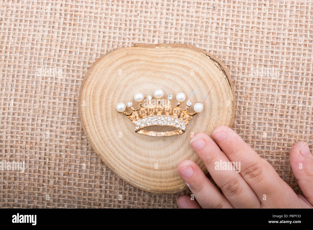 Hand holding a little model crown in hand Stock Photo - Alamy
