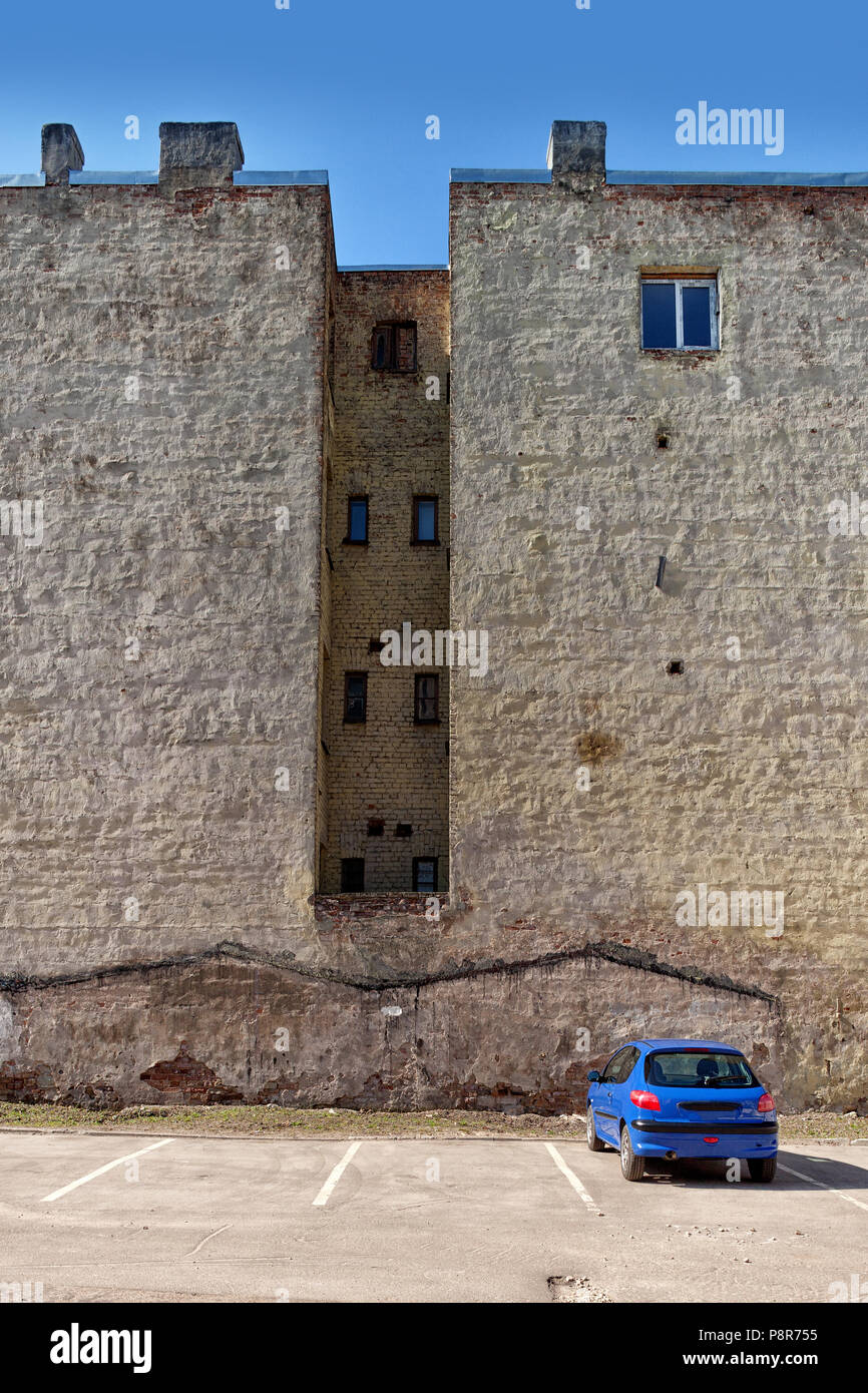 Blue car parked at the house wall with a window and pipes Stock Photo ...