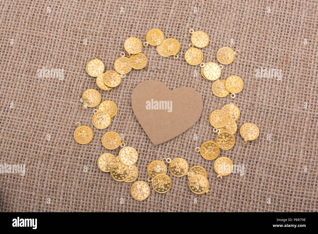 Fake gold coins around heart shape made of paper Stock Photo - Alamy