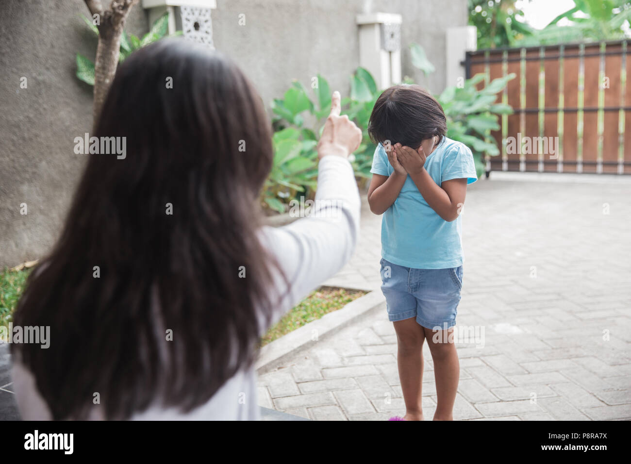 Angry mother scolding daughter covering her face in living room Stock Photo - Alamy